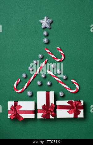 Candy canes with Christmas balls, gift and fir branches on red ...