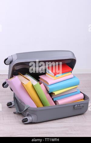 Books in suitcase on wall background close-up Stock Photo - Alamy