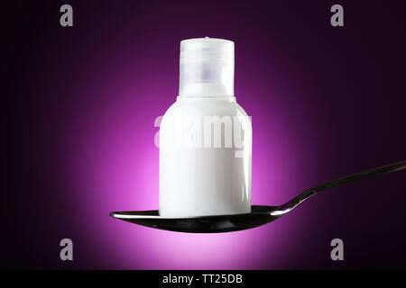 Cosmetic bottle in silver spoon on yellow background Stock Photo - Alamy