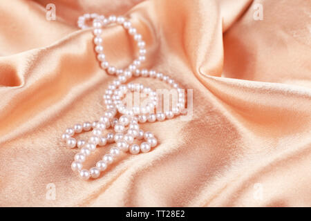 Beautiful pearls on golden silk cloth Stock Photo - Alamy