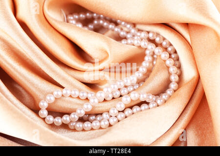 Beautiful pearls on golden silk cloth Stock Photo - Alamy