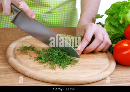 Female hands chopping dill on wooden board, close-up, isolated on white ...