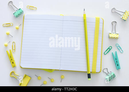 Open notebook with empty pages and other office supplies over wooden ...