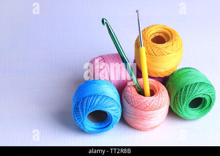 Colorful clews and crochet hooks on light background Stock Photo - Alamy