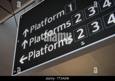 a railway station platform sign with the number 1 next to shabby ...