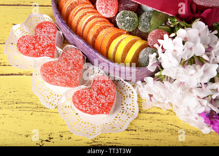 Present box with sweets and flowers on table on bright background Stock ...