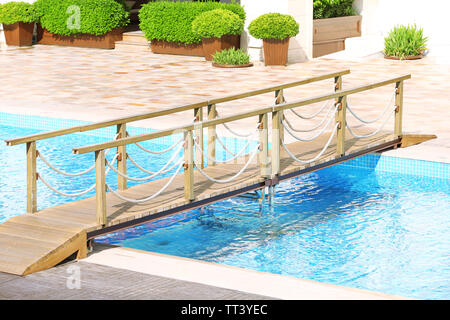 Bridge across hotel swimming pool Stock Photo - Alamy