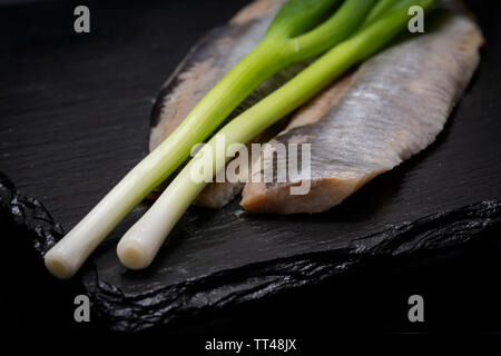 Salt Herring Fillets and Organic Green Onion Scallions arranged on ...