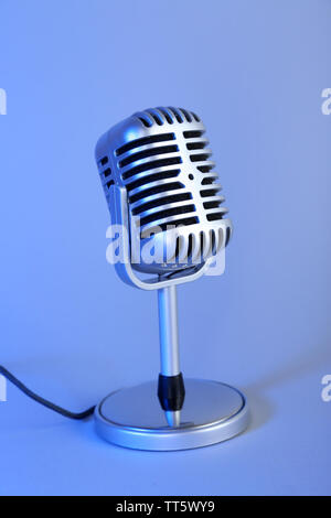 Old metal microphone on light blue background Stock Photo - Alamy