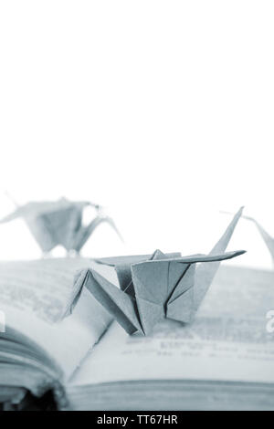 Origami cranes on old book, on white background Stock Photo - Alamy