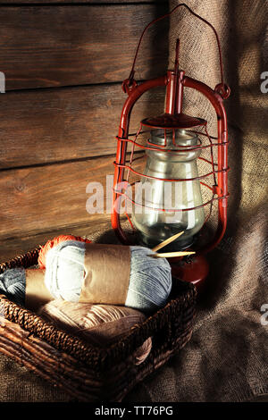 Kerosene lamp with yarn and needles for knitting in wicker basket on ...