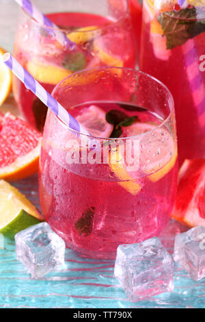 Pink lemonade in glasses and pitcher on table on natural background ...