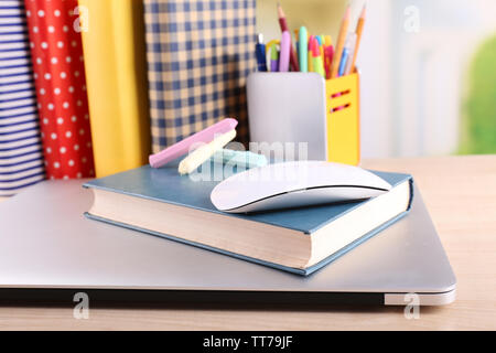 Books, computer mouse and pieces of chalk on wooden table and light ...