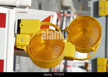 Orange construction site lamps at a construction site barrier, Germany ...