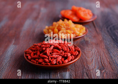 Dried fruits in small plates on rustic wooden table background Stock ...