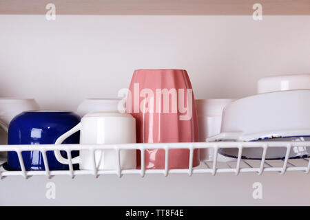 Clean cups drying on metal dish rack close up Stock Photo - Alamy