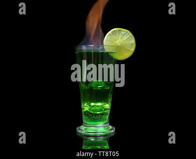 Flaming green cocktail on dark background Stock Photo - Alamy