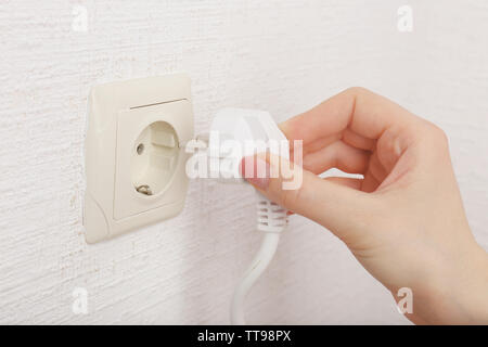 hand putting plug into 3-pin electric socket Stock Photo - Alamy