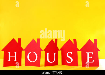 Color paper houses on yellow background Stock Photo - Alamy