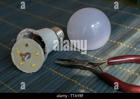 disassembled led household lamp with a burnt led element is on the ...