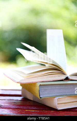 Stack of books outdoors, on blurred background Stock Photo - Alamy
