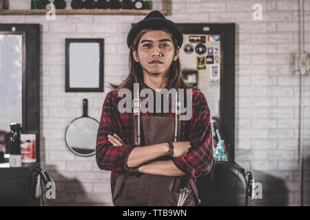 portrait of fashionable barber man hairstylist posing and standing with ...