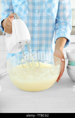 Young woman making rainbow cake in kitchen Stock Photo - Alamy