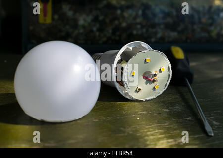 disassembled led household lamp with a burnt led element is on the ...