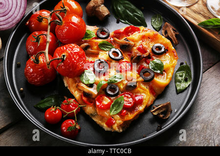 Decorated pizza with vegetables on pan on wooden background Stock Photo ...