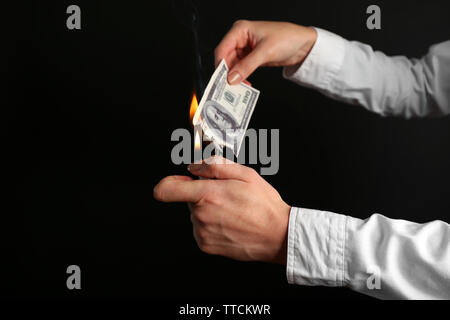 Woman burning dollars on black background Stock Photo - Alamy