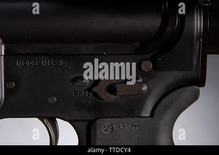 Safety lever on safe on a rifle with trigger visible on a white ...
