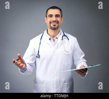 Portrait of a doctor with prescription board in hands isolated on white ...