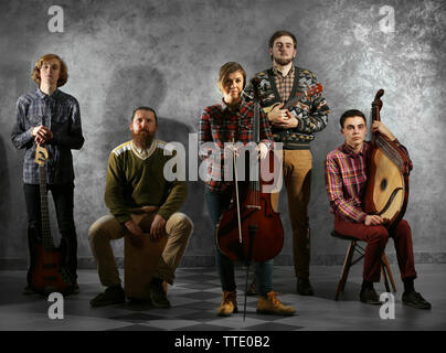 Musical band on grey wall background Stock Photo - Alamy