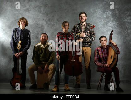 Musical band on grey wall background Stock Photo - Alamy