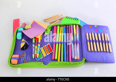 Pencil case with various stationery on wooden table Stock Photo - Alamy