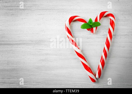 Lollipop candies like heart with mint on light background Stock Photo ...