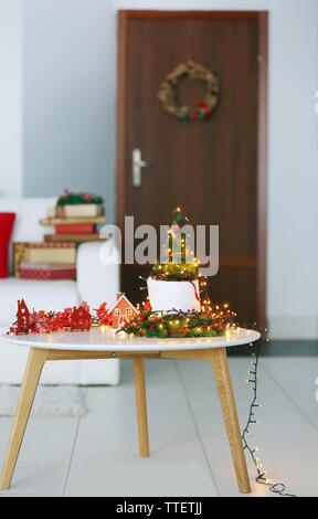 Living room with small pine table and box between neutral curtains ...
