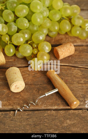 Wine corks and tailspin with bunch of grapes on wooden background Stock ...