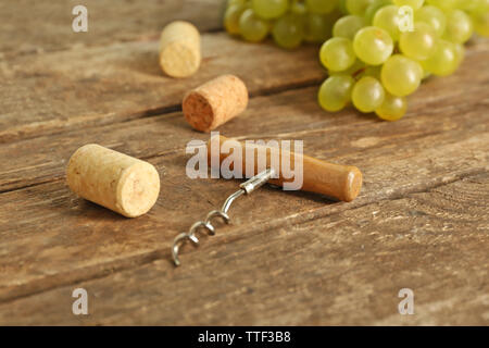 Wine corks and tailspin with bunch of grapes on wooden background Stock ...