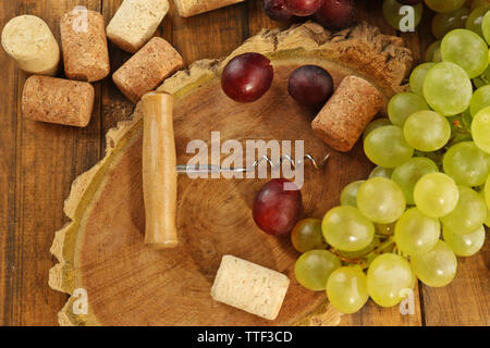 Wine corks and tailspin with bunch of grapes on wooden background Stock ...