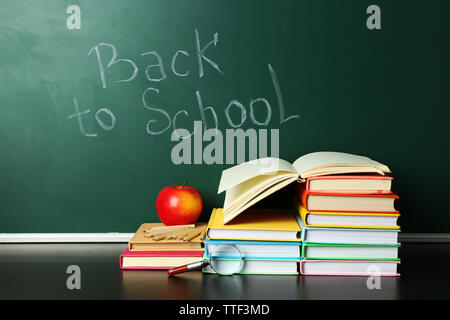 School books on desk near chalkboard Stock Photo - Alamy