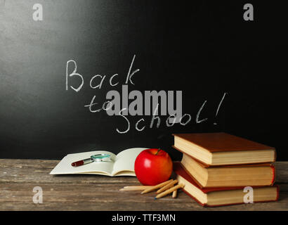 School books on desk near chalkboard Stock Photo - Alamy