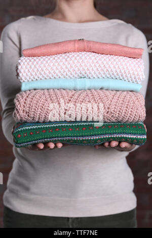 Woman hold clothes pile against grey background, close up Stock Photo ...