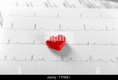 Cardiogram chart with small red heart on table closeup Stock Photo - Alamy