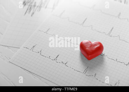 Cardiogram chart with small red heart on table closeup Stock Photo - Alamy