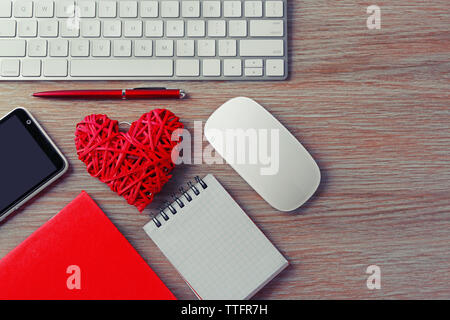 Computer peripherals with white wicker heart, notebook and mobile phone ...