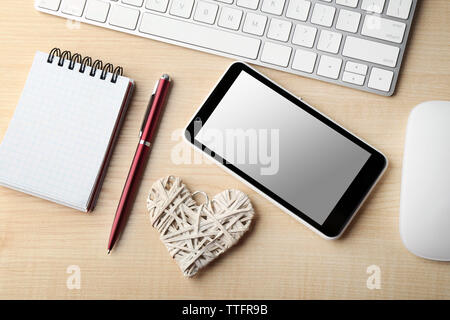 Computer peripherals with white wicker heart, notebook and mobile phone ...