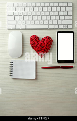 Computer peripherals with red heart, notebook and mobile phone on light ...