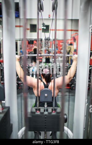 Strong woman completes shoulder pull-down at the gym Stock Photo - Alamy