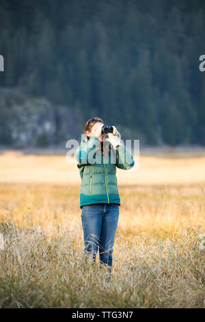 Bird watching. Woman biologist with binoculars observes wildlife ...